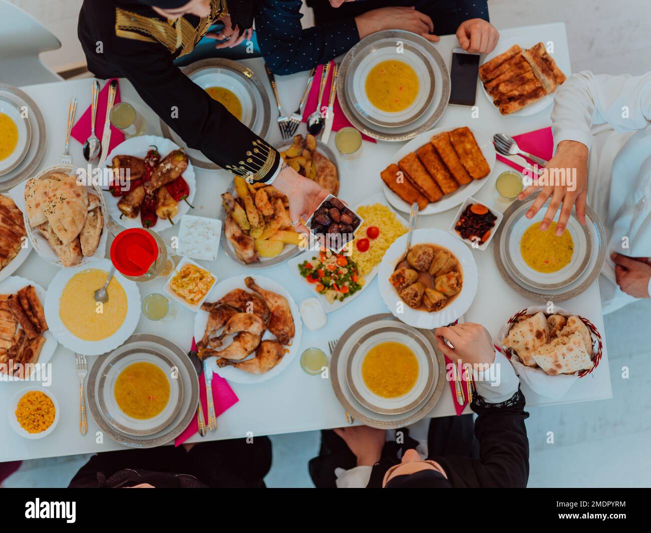Top view of Muslim family having Iftar dinner drinking water to break ...