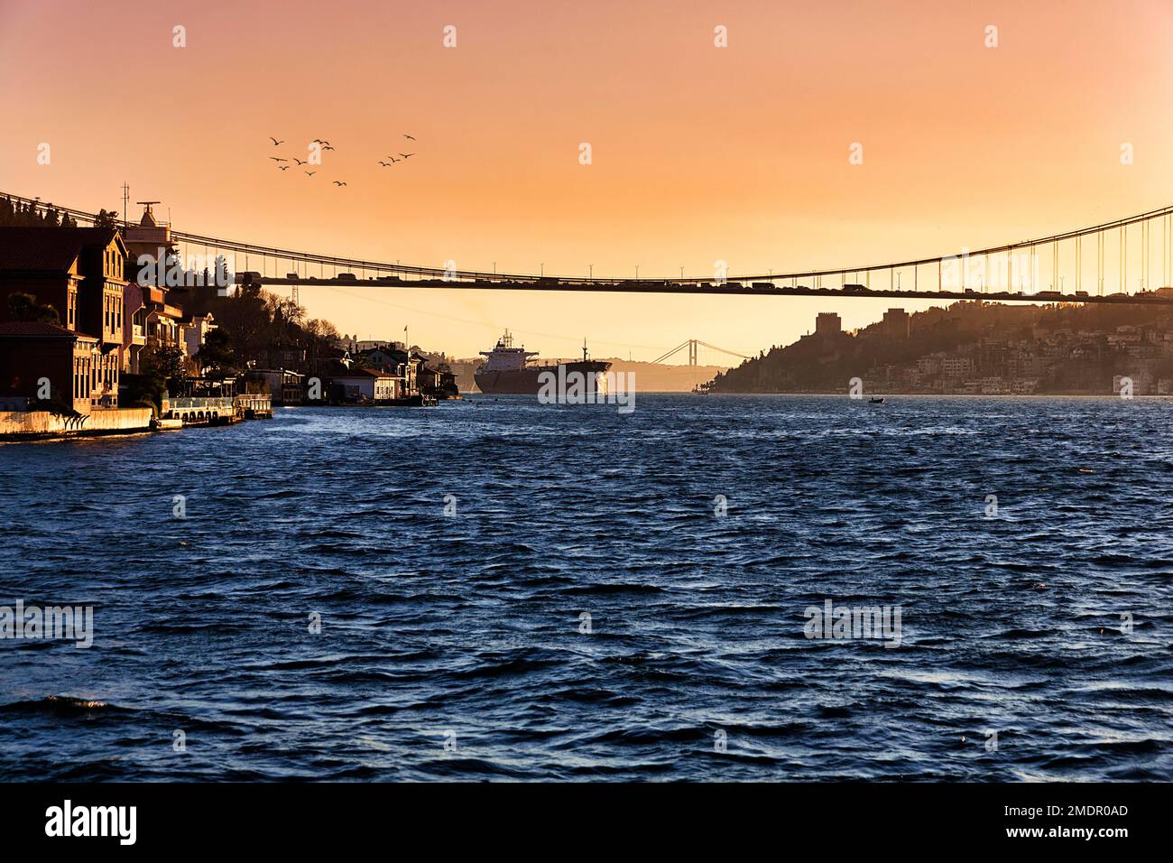 Cargo ship under the Fatih Sultan Mehmet Bridge, sunset, Bosphorus ...