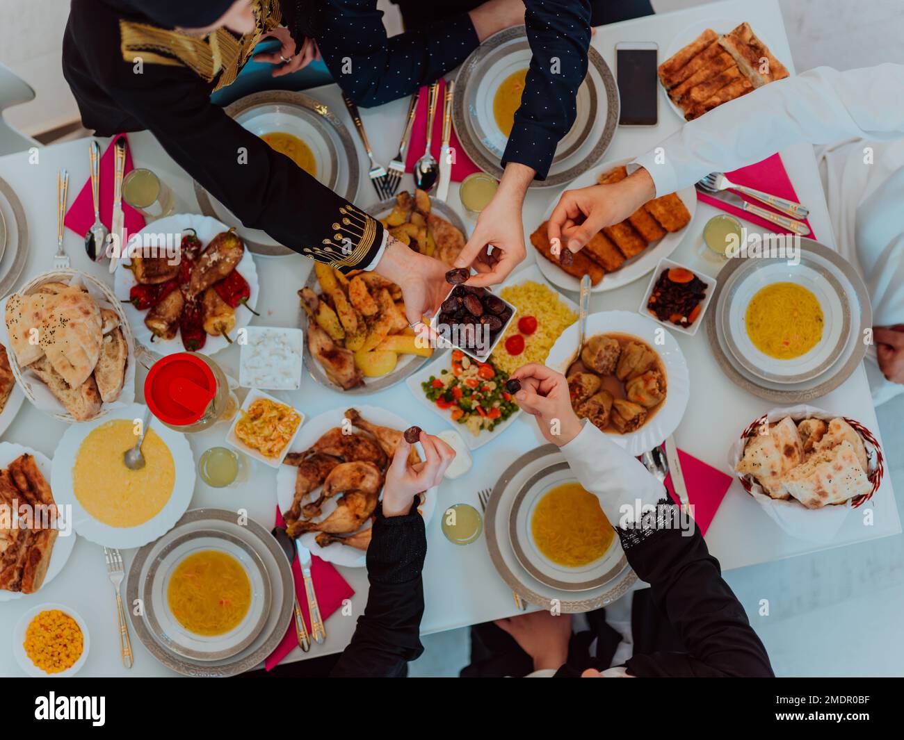 Top view of Muslim family having Iftar dinner drinking water to break ...