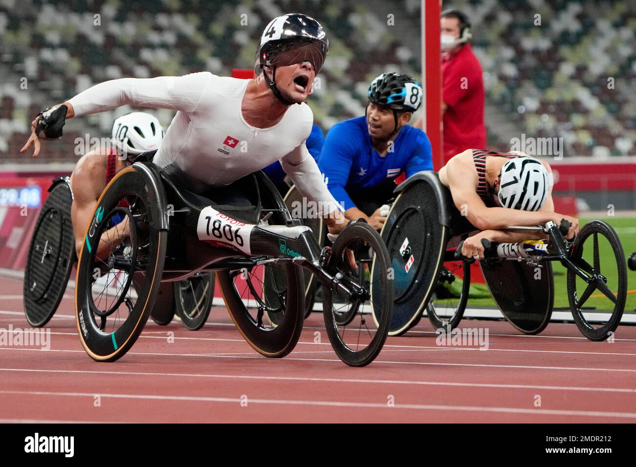 Switzerland's Marcel Hug, right, reacts as he crosses the finish line ...