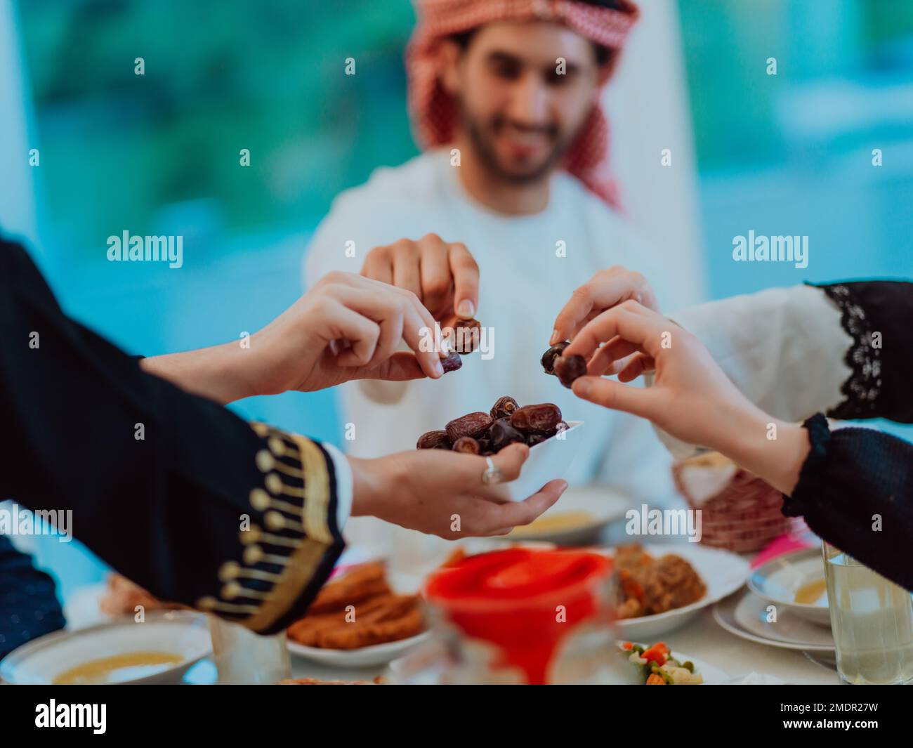 Modern multiethnic muslim family sharing a bowl of dates while enjoying ...