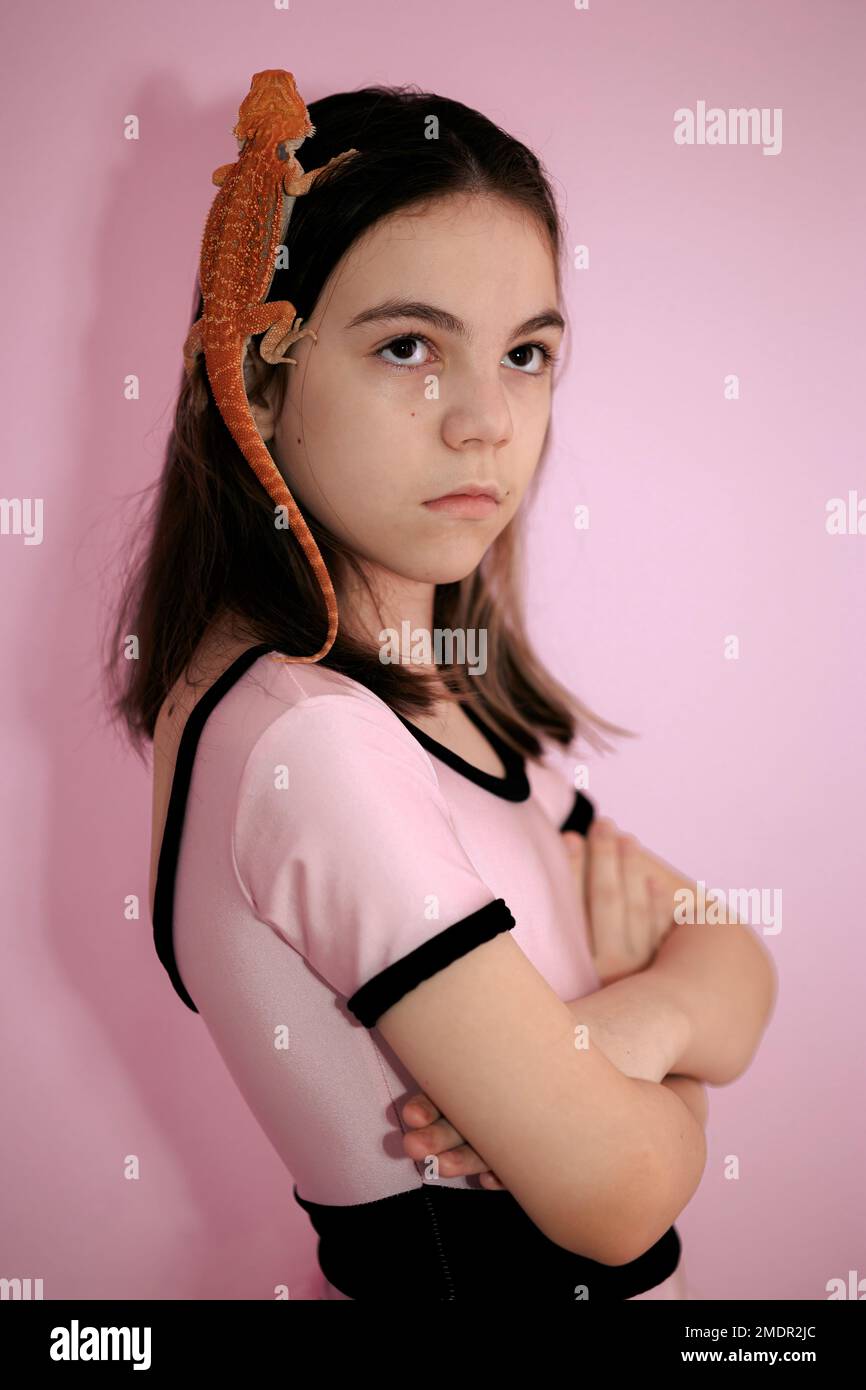 Portrait of pretty girl with Red bearded Agama iguana on pink ...