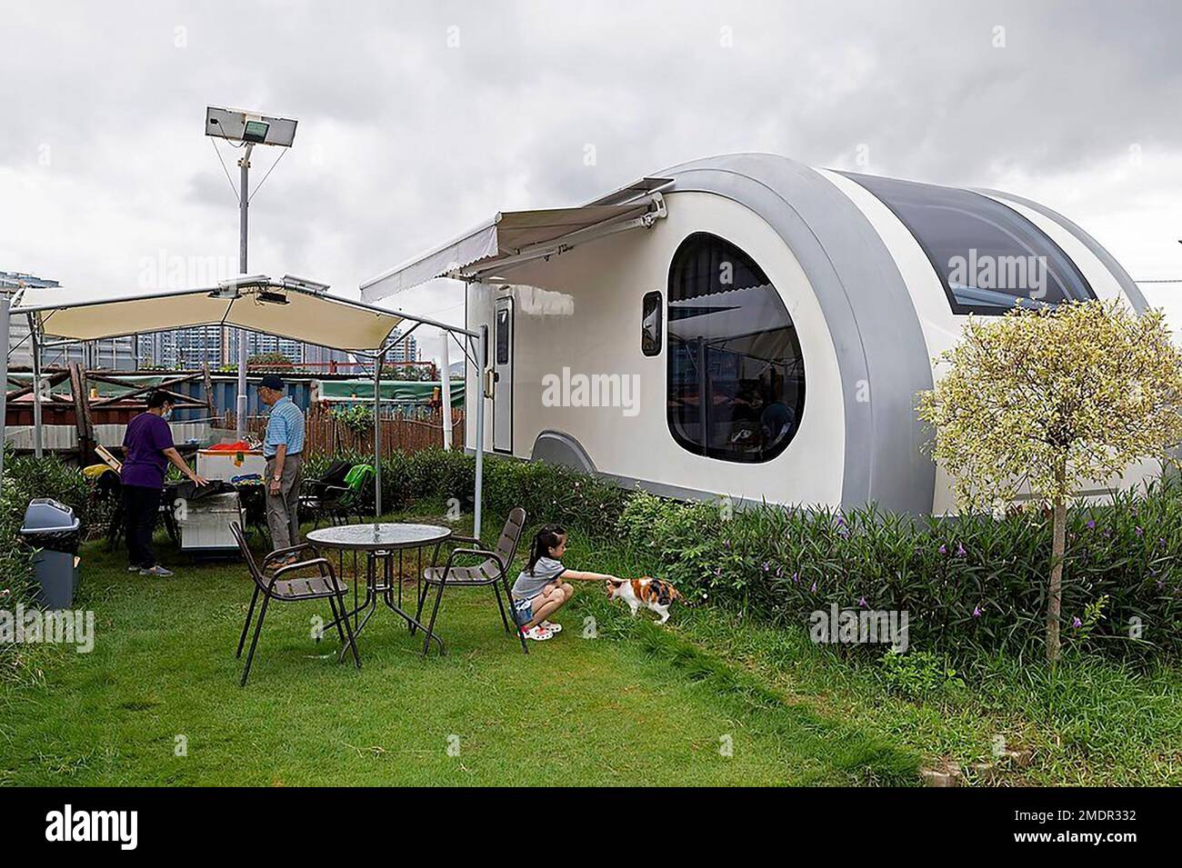 A couple cleans up the table outside the signature stargazing caravan ...