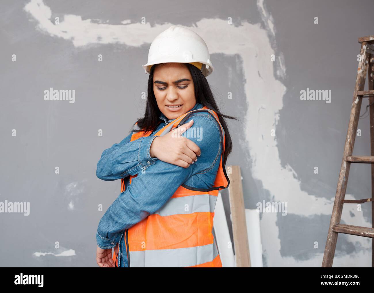 Construction worker holds shoulder in pain from workplace injury on ...