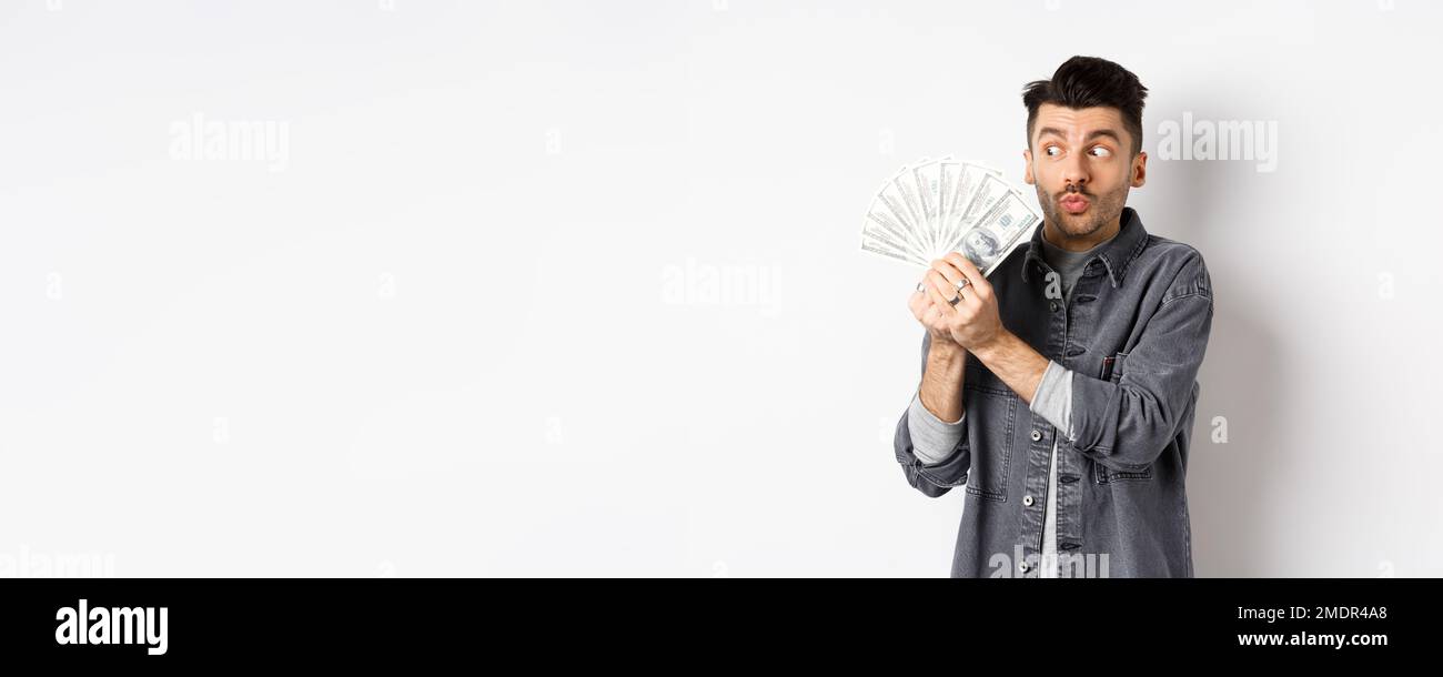 Excited man hugging and kissing dollar bills, holding money and ...