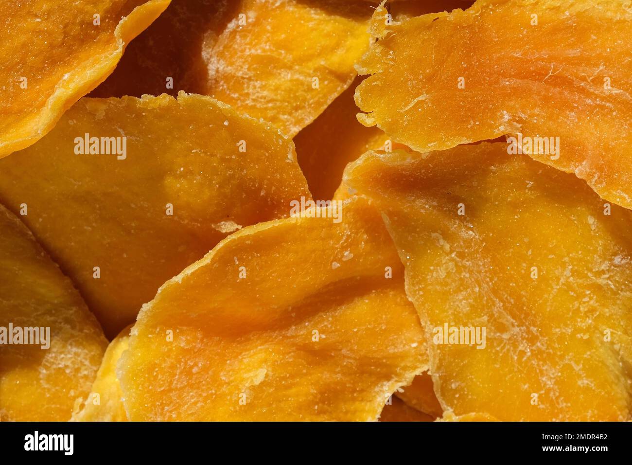 Dried mango slices close-up on a white. Top view. Closeup. Mango chips ...