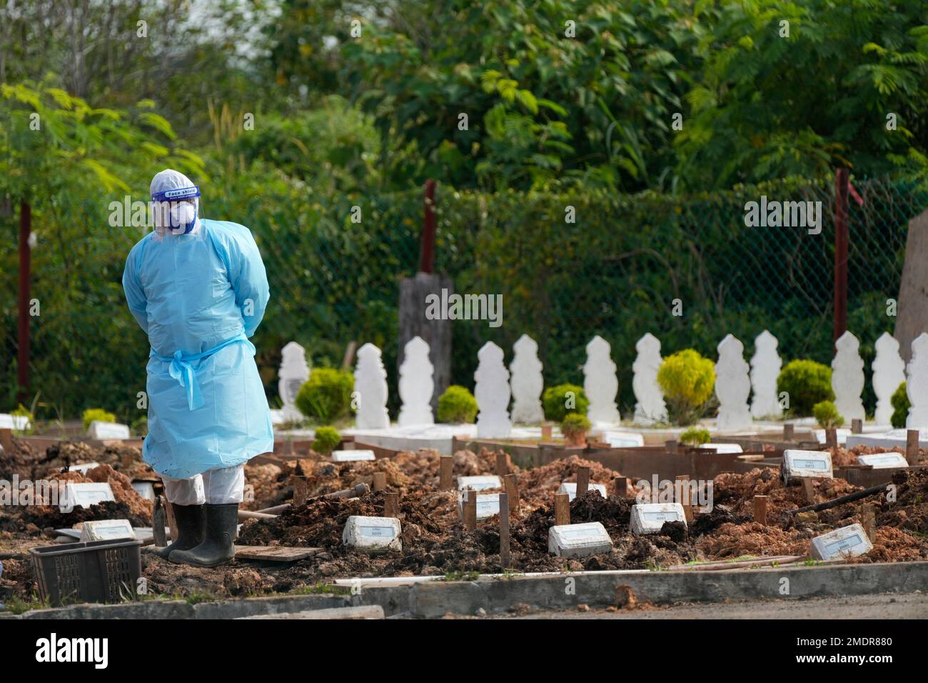 A health worker wearing Personal Protective Equipment (PPE) stands ...