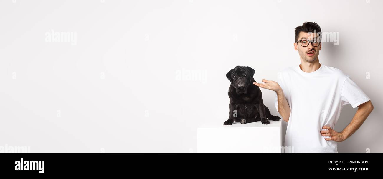 Confused man seeing something strange, staring at camera puzzled ...