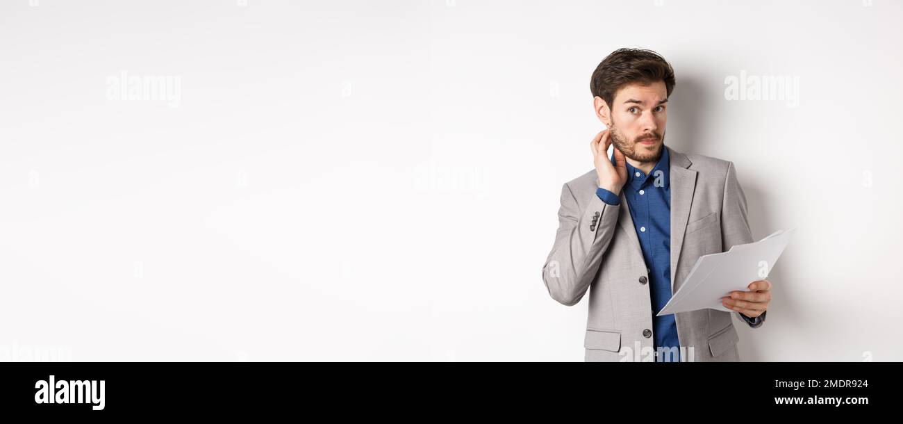 Confused office worker in suit scratching beard and look clueless, cant ...