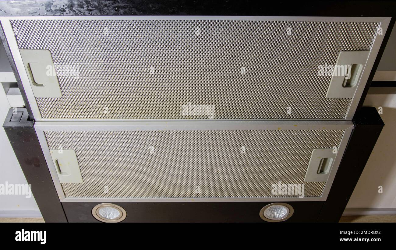 Modern kitchen hood with grease filter for air purification. Replacing ...