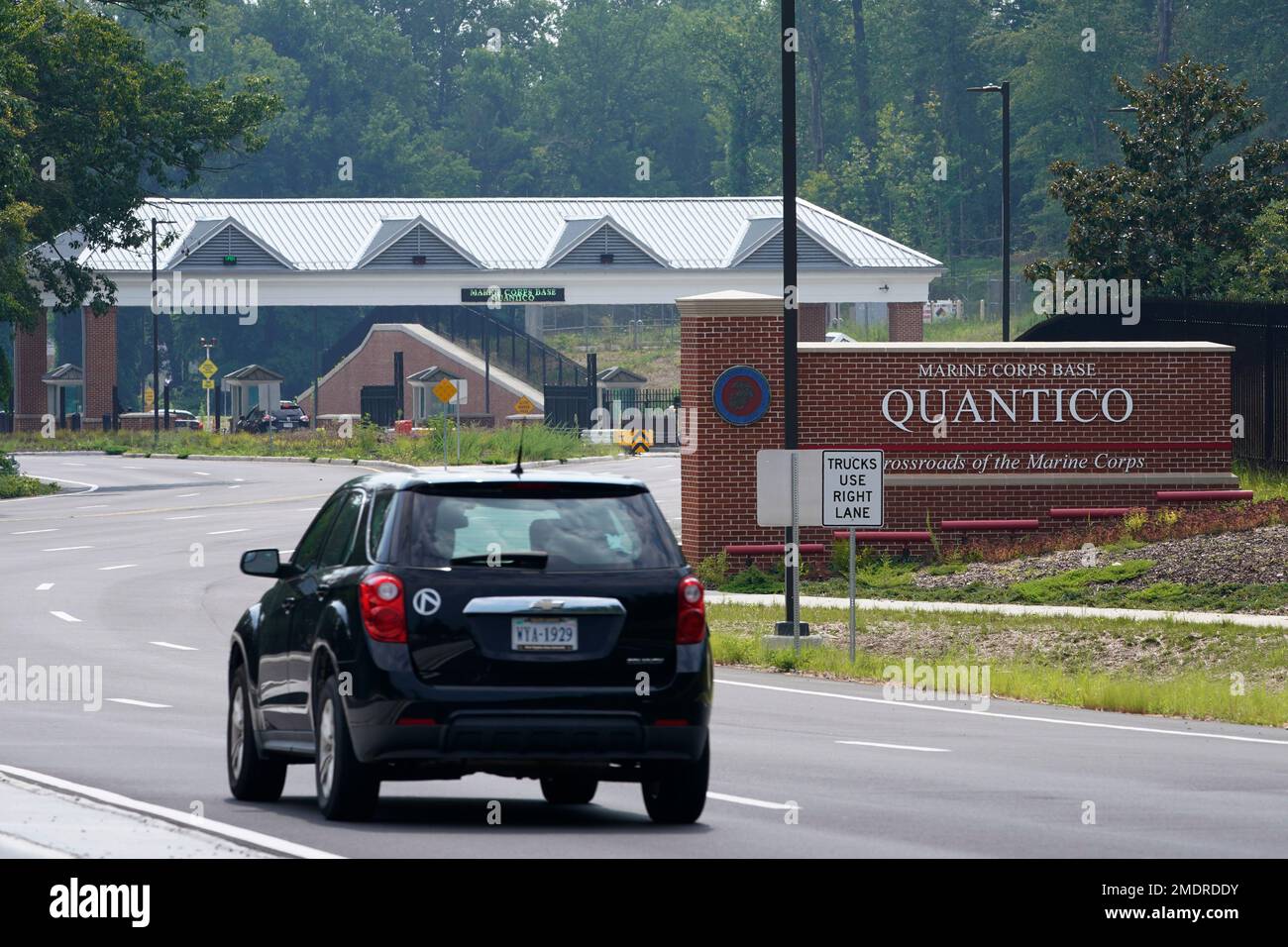 Traffic drives past the entrance sign of Marine Corps Base Quantico ...