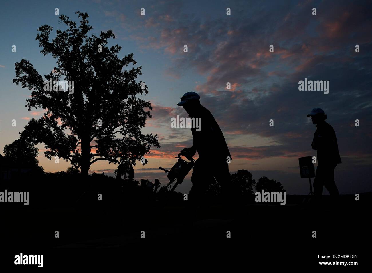 Members of the grounds crew prepare the putting green at Caves Valley ...
