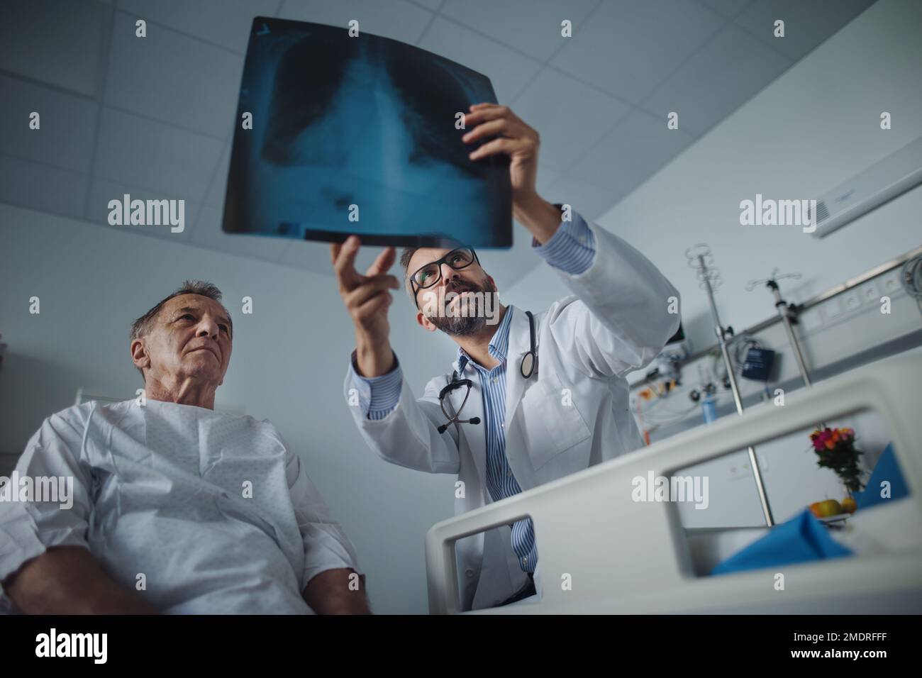 Mature doctor showing elderly patient x-ray image of lungs Stock Photo ...