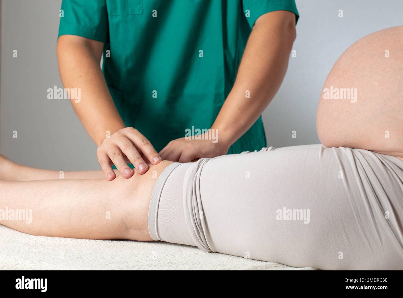 Doctor massage therapist makes massage on the legs and knee joints of a ...