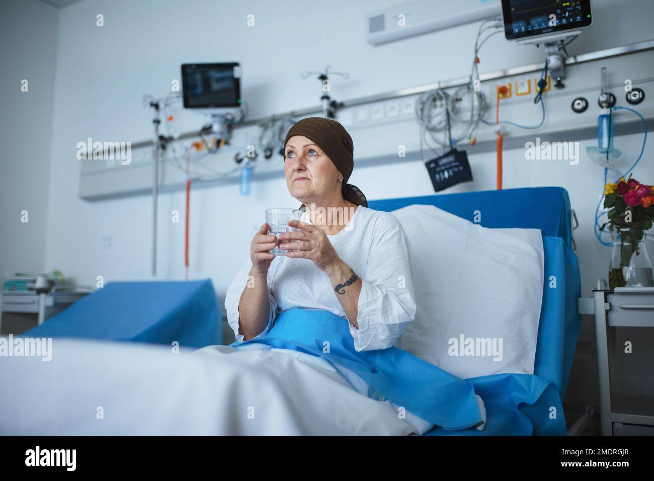Senior woman sitting in hospital room after chemotherapy Stock Photo ...