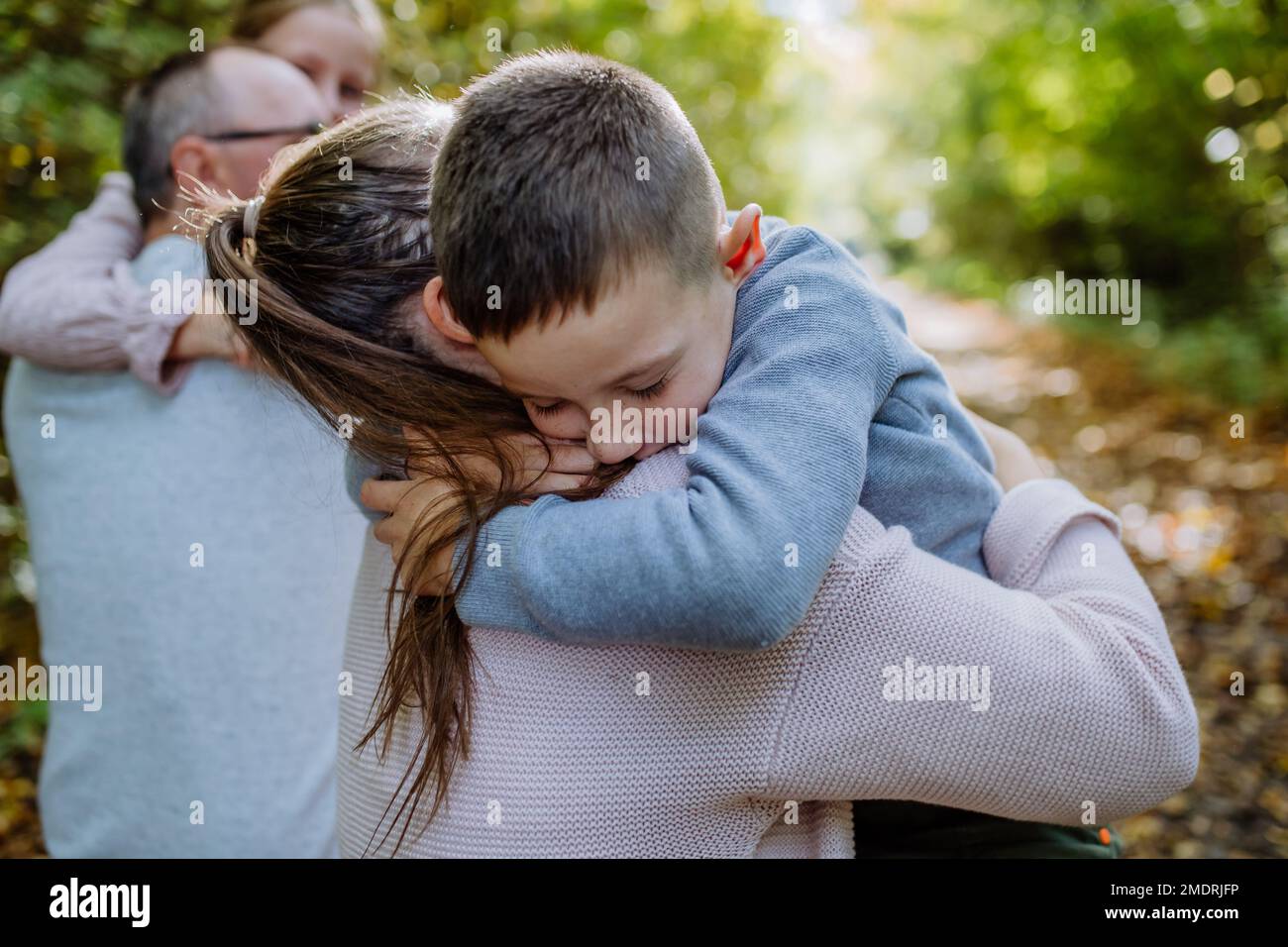 Little boy embracing his mother during family walk in forest Stock ...