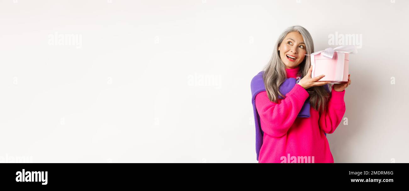 Holidays and valentines day concept. Happy asian mature woman shaking ...