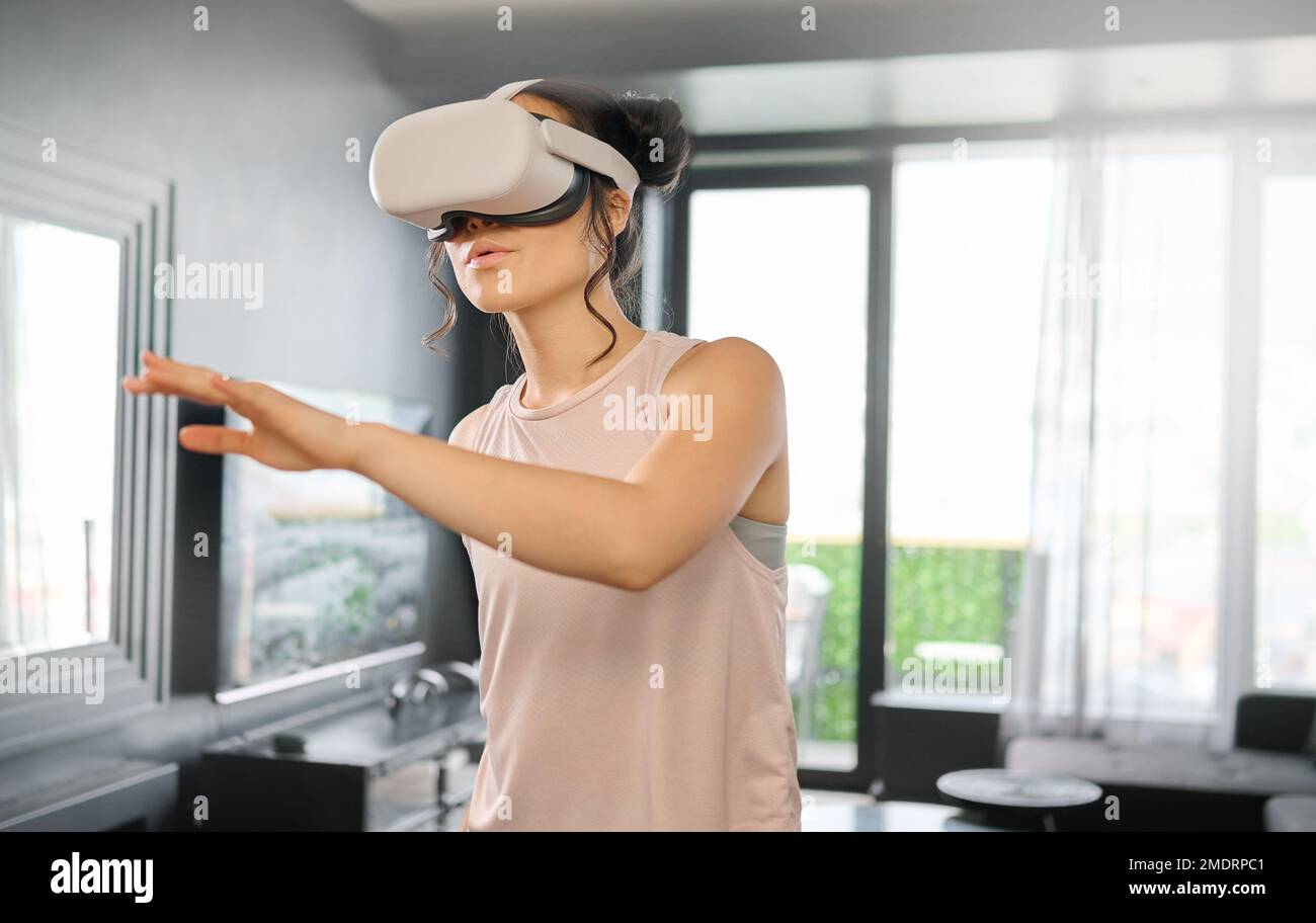 Virtual reality, metaverse and technology with a woman in the living ...