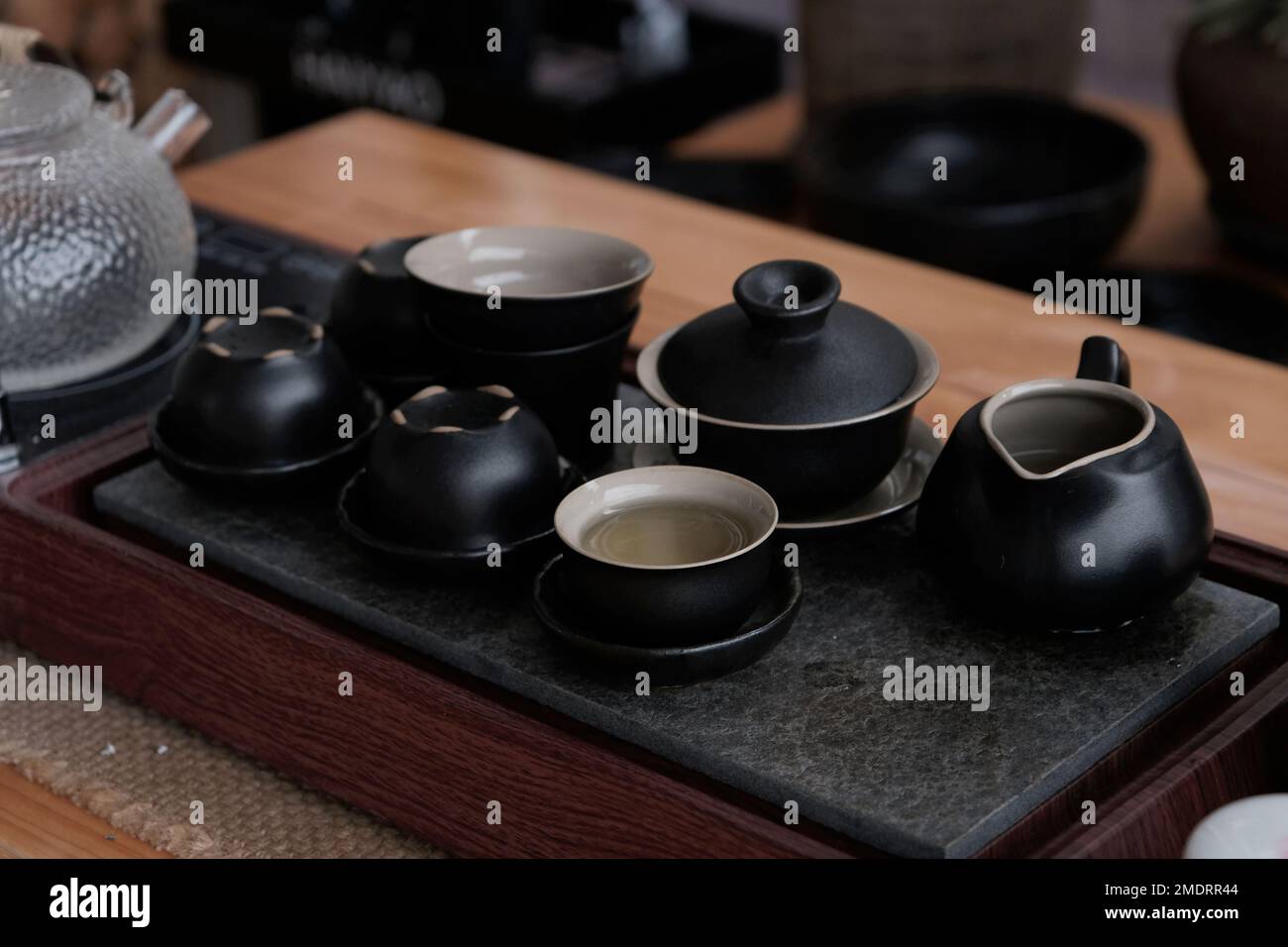 A closeup of matte black tea set on a wooden table Stock Photo - Alamy