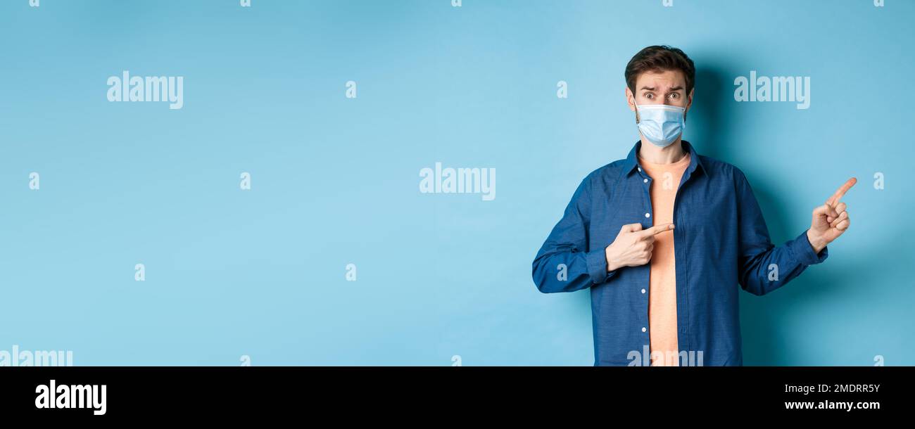 Covid and healthcare concept. Worried young man in medical mask raising ...