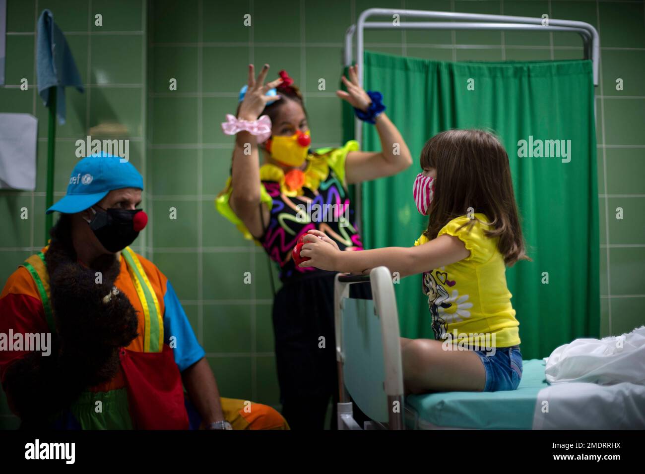 A girl is entertained by clowns as she waits in the control room after ...