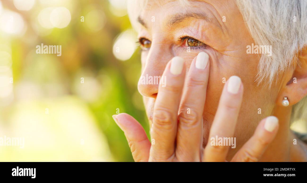 The sad nostalgia of passed youth. Closeup shot of a sad senior woman ...