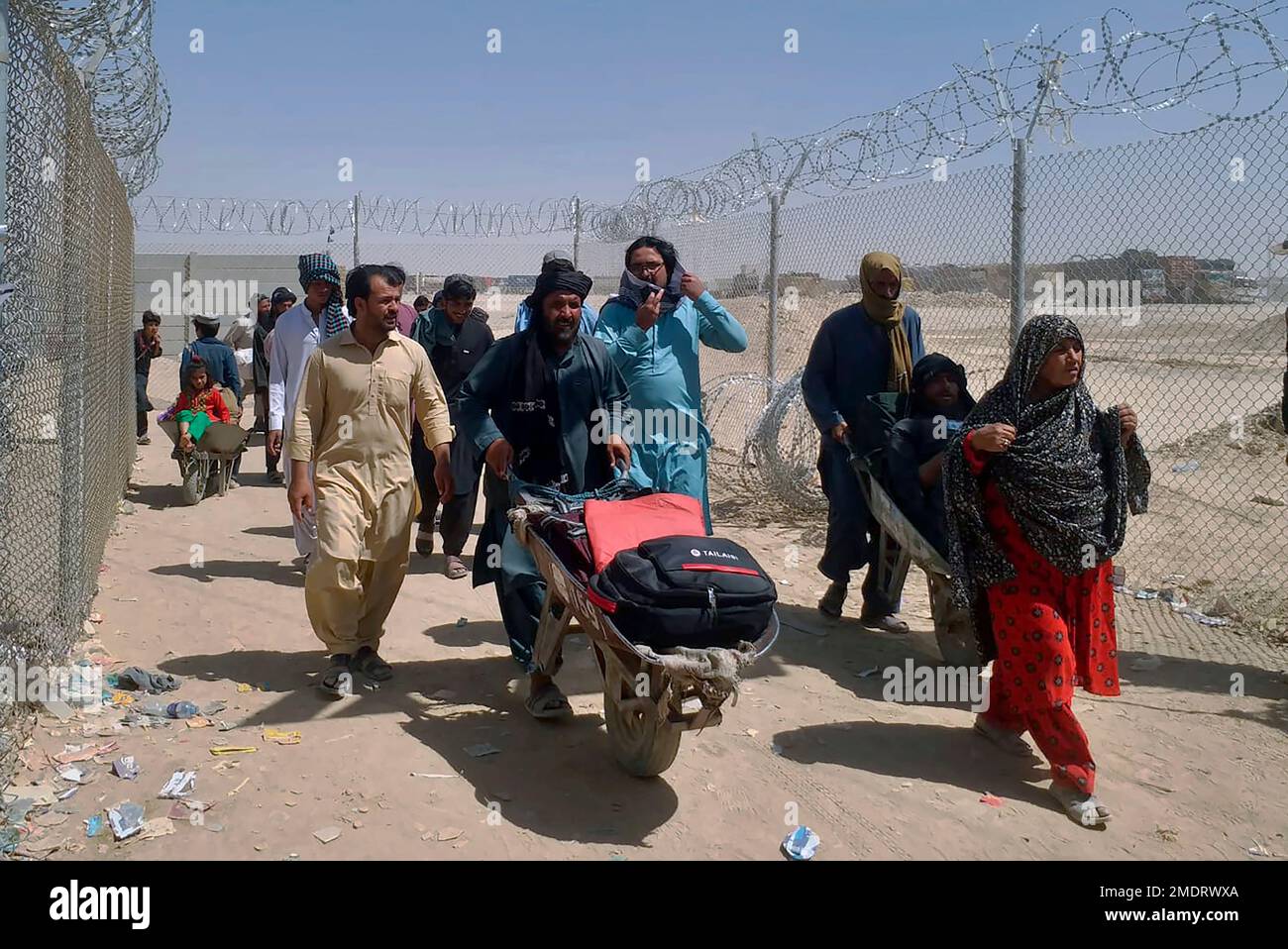 Afghan families enter Pakistan through a border crossing point in ...
