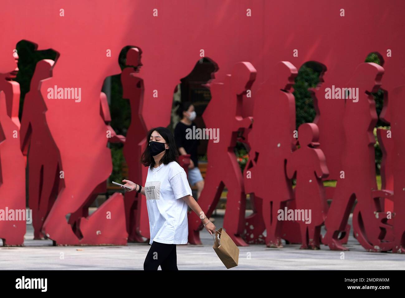 Women wearing face masks to help protect from the coronavirus walk by ...