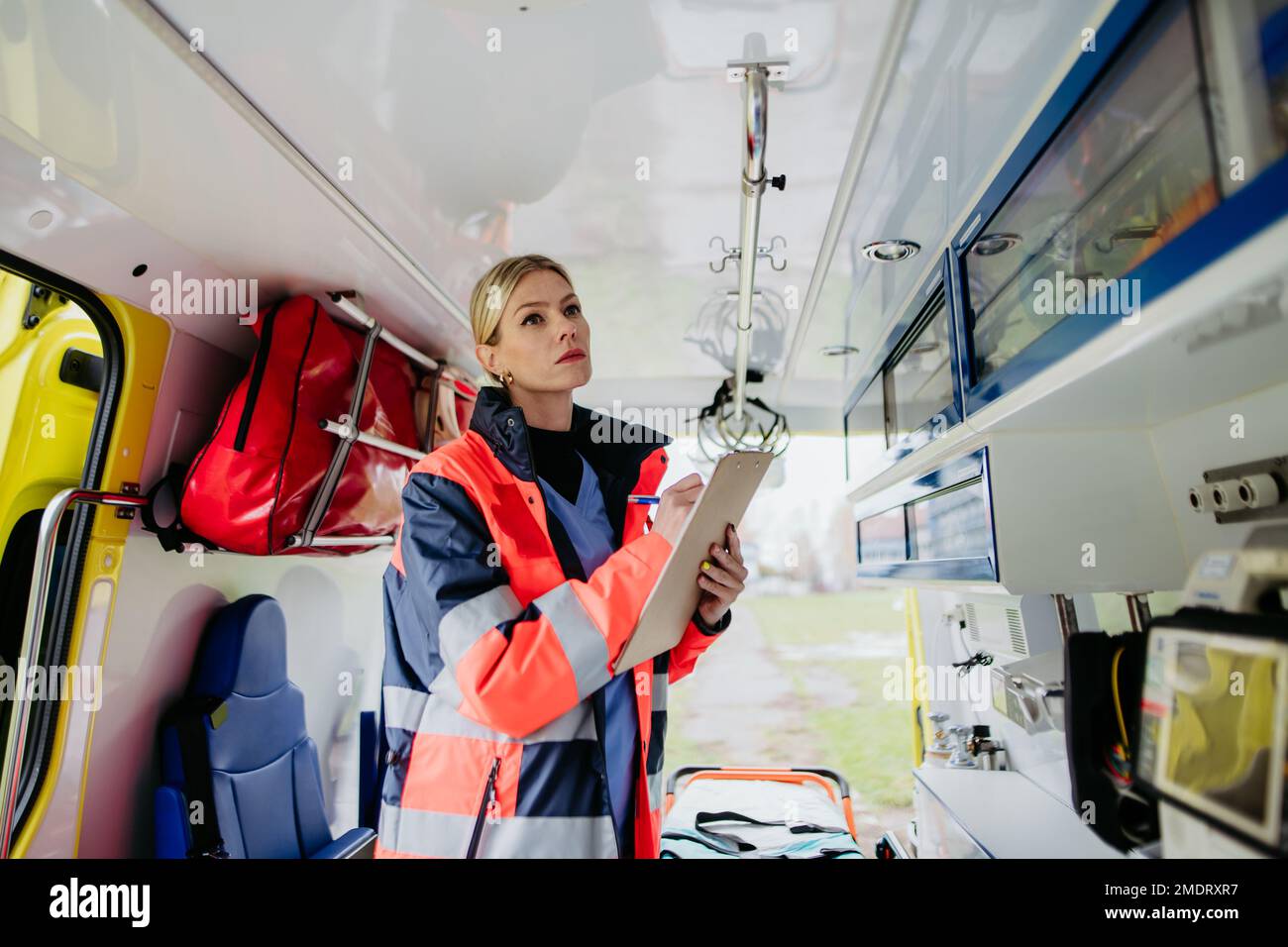 Young rescuer doctor checking equipment in ambulance car Stock Photo ...