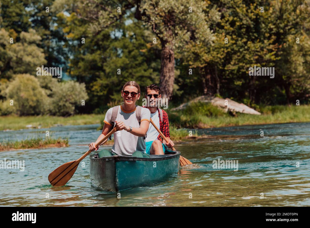 Couple adventurous explorer friends are canoeing in a wild river ...