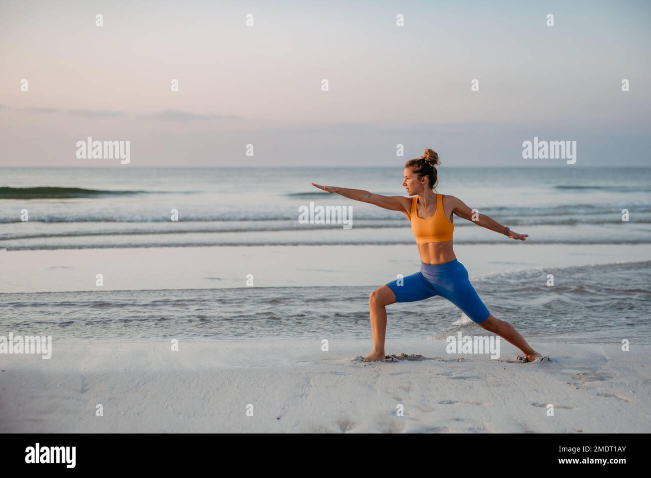 Young woman taking exercises at beach, morning routine and healthy ...