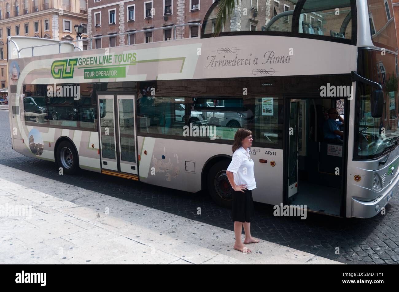 Woman tour guide standing next to open topped tourist bus in Rome ...
