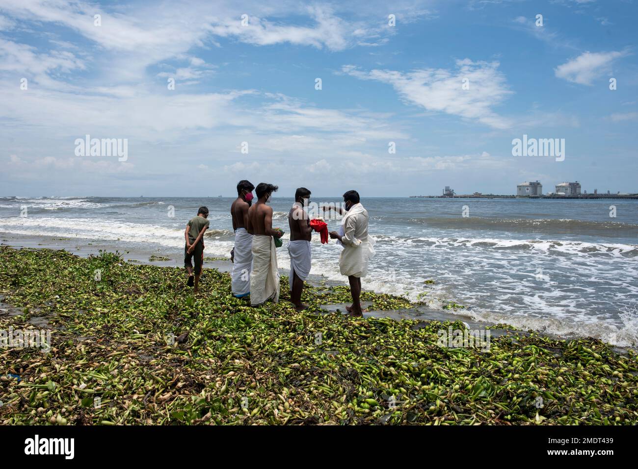 A group of young men wearing masks as a precaution against the ...