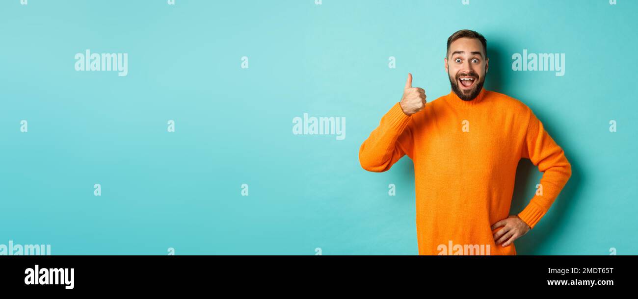 Well done. Handsome bearded man showing thumb up, praising good work ...