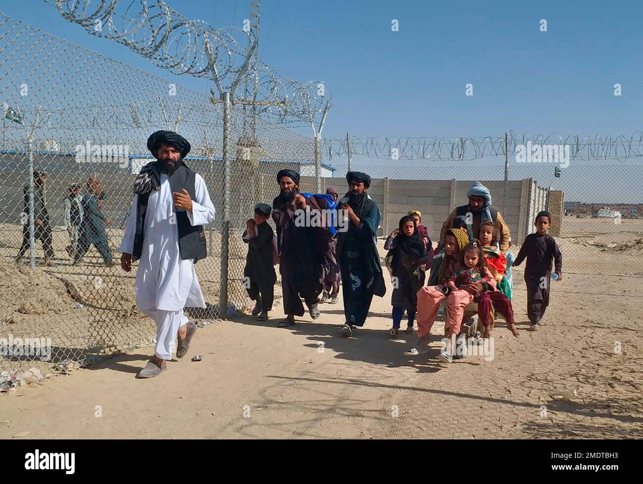 Afghan families enter into Pakistan through a border crossing point in ...