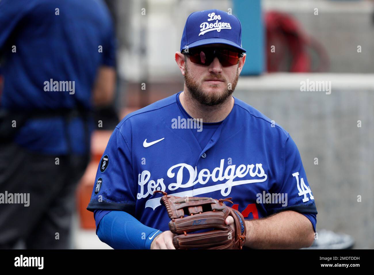Los Angeles Dodgers' Max Muncy walks in the dugout wearing a new Los ...