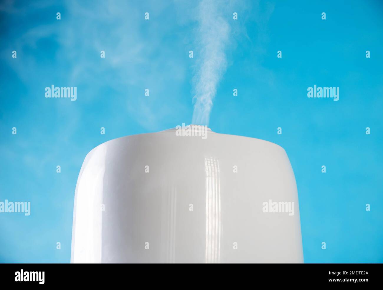 Modern air humidifier on a blue background. Humidification in the room ...