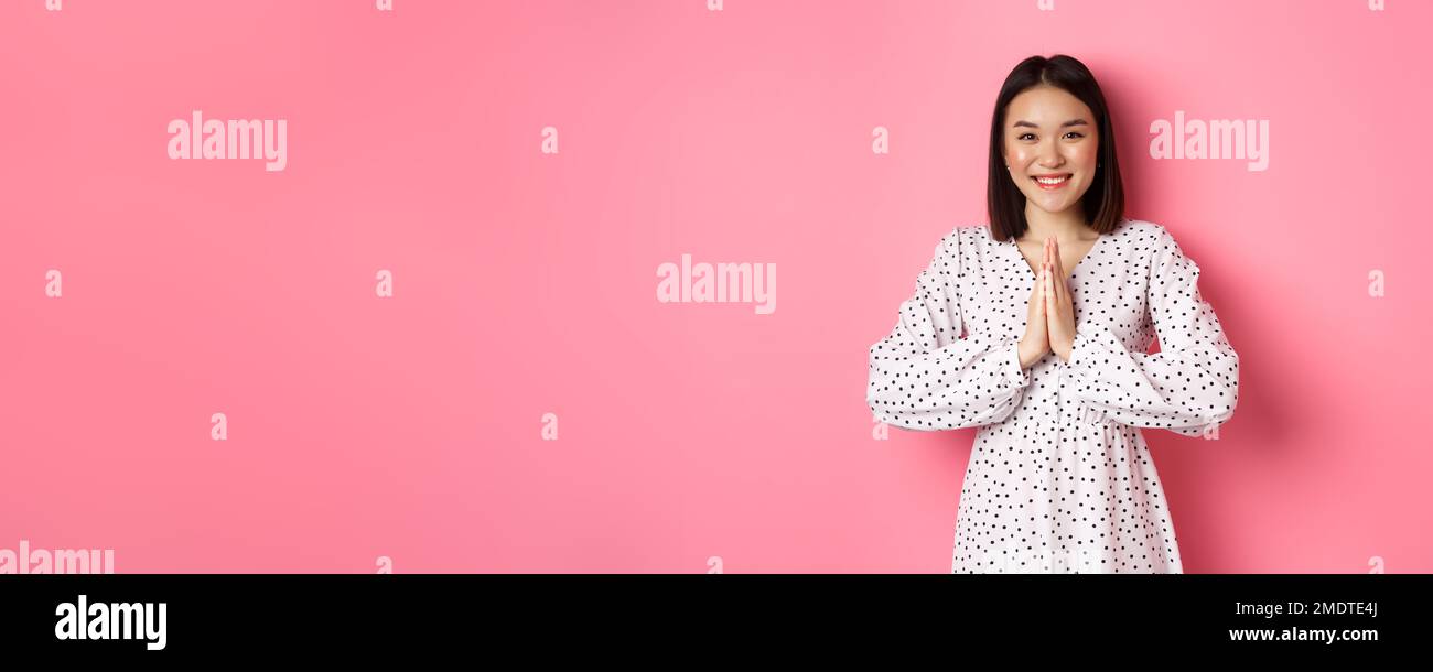 Beautiful asian woman thanking you, holding hands together in ...