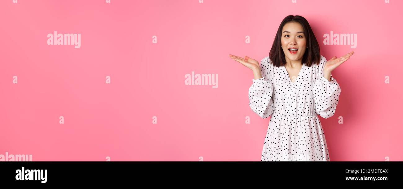 Image of surprised korean girl in dress, female model staring at camera ...