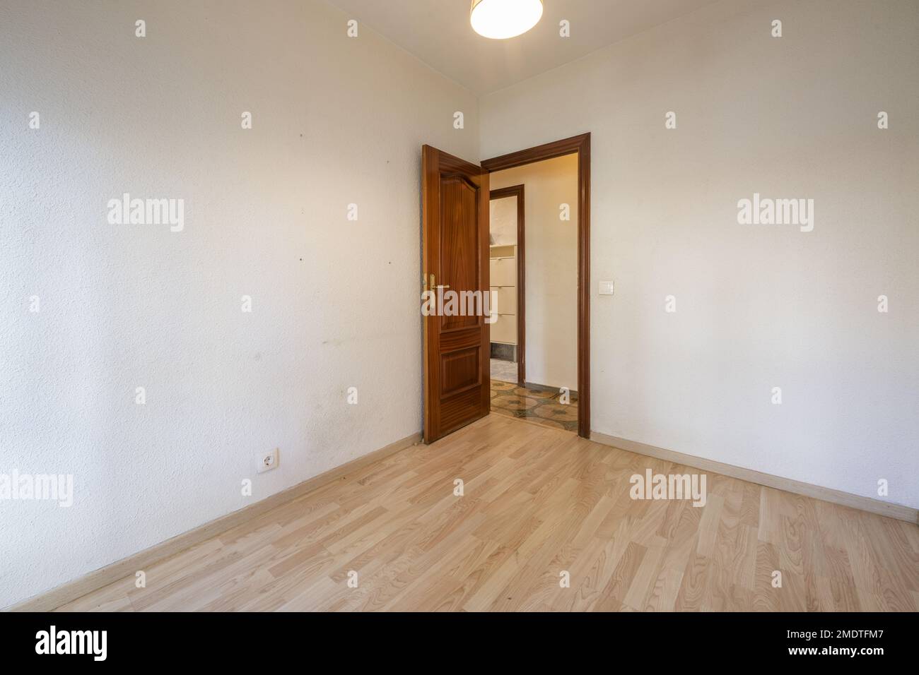 Small empty room with laminated flooring and sapele wood access door ...