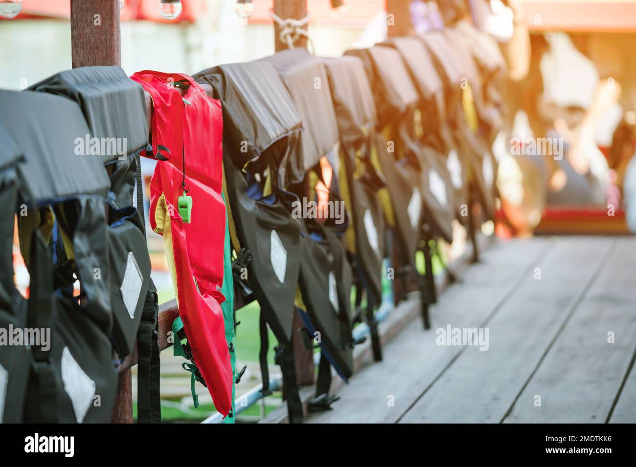 A green whistle with red life jacket hanging on the railing around the ...