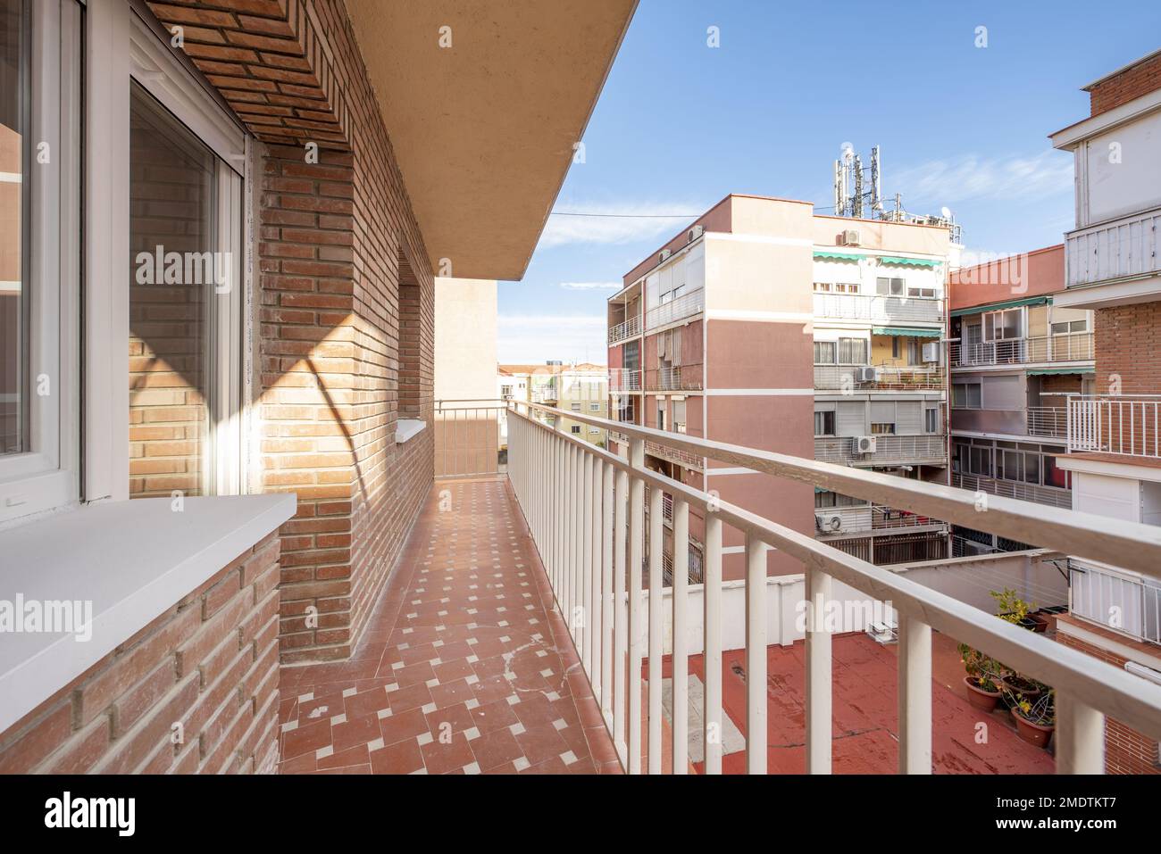 Elongated viewing terrace with white metal railing and views of a block ...