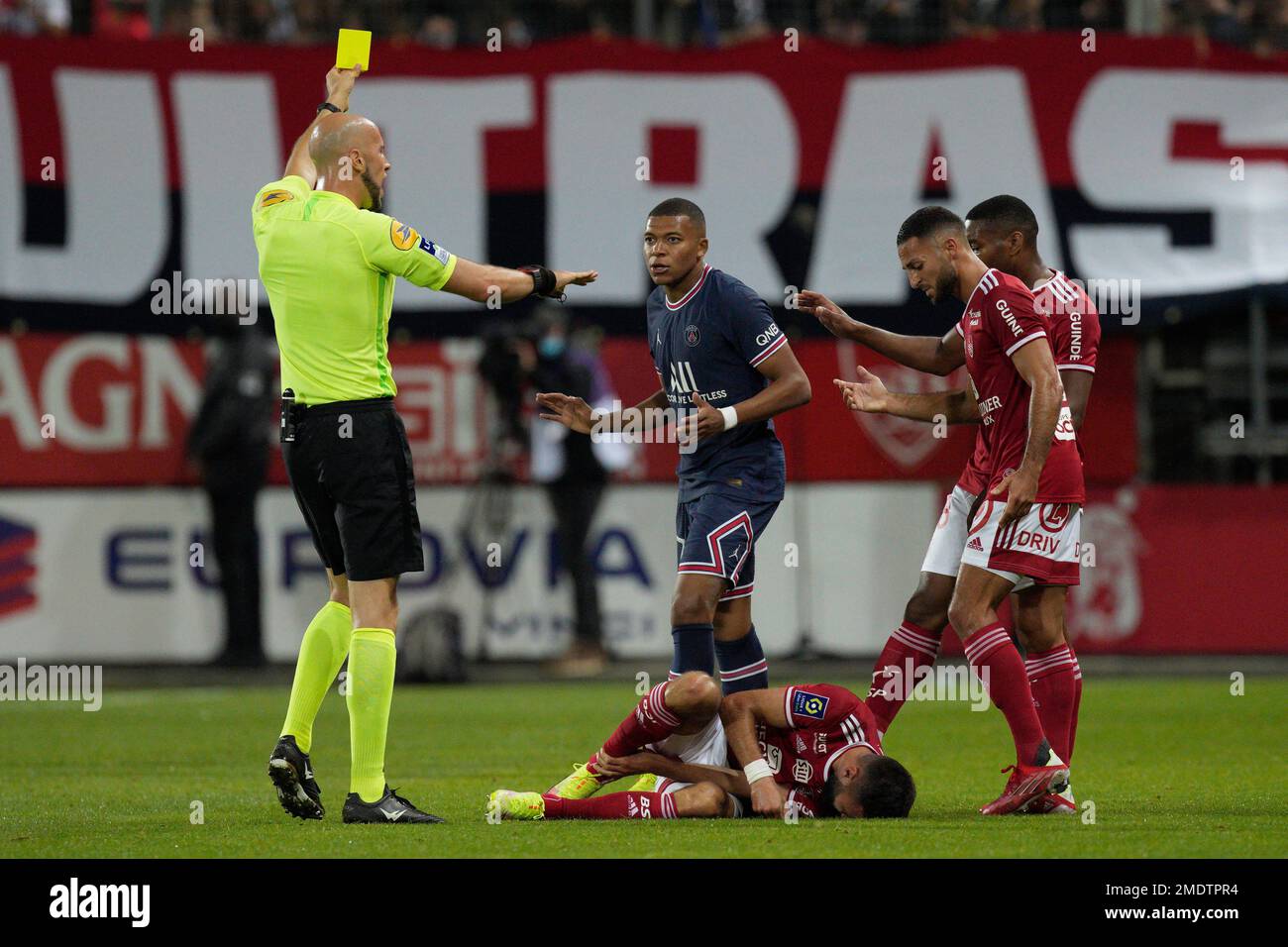 PSG's Kylian Mbappe, center, is shown a yellow card by referee Eric ...
