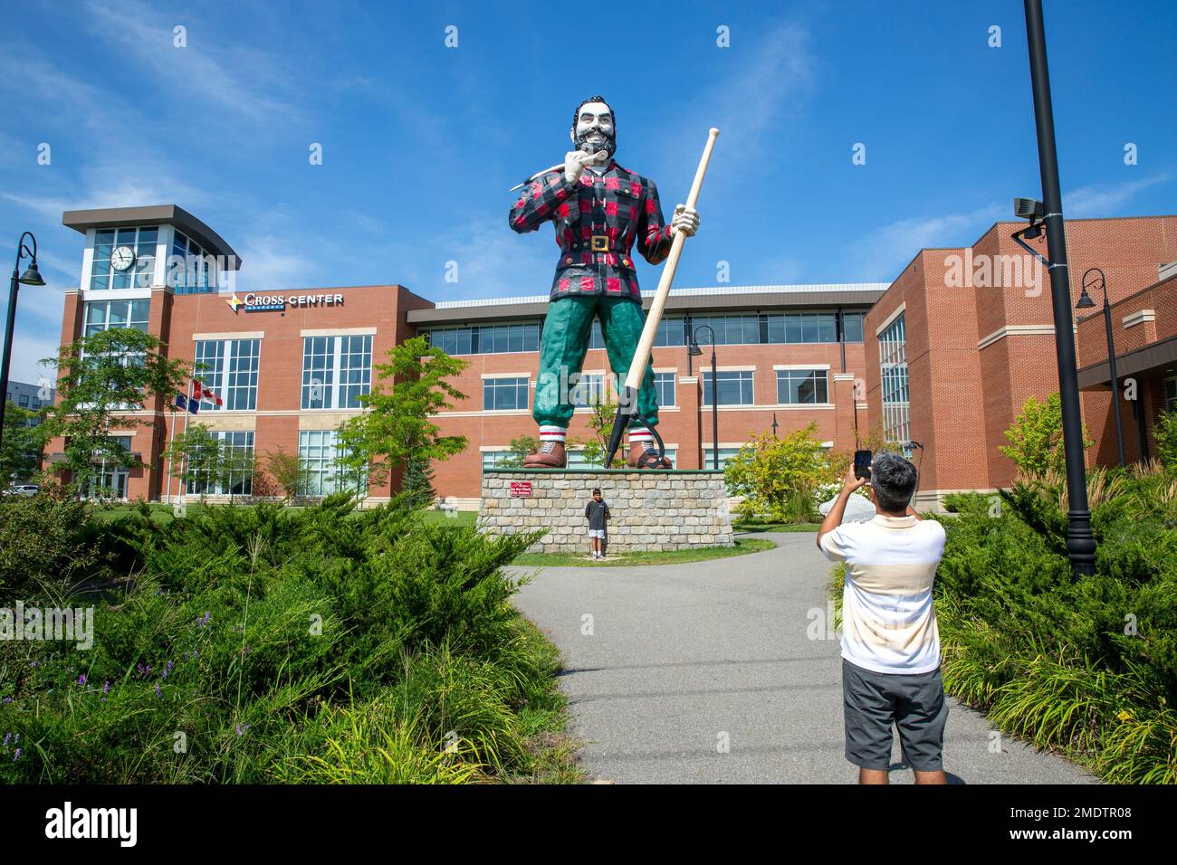 People pose for photos in front of a tall statue of Paul Bunyan in ...