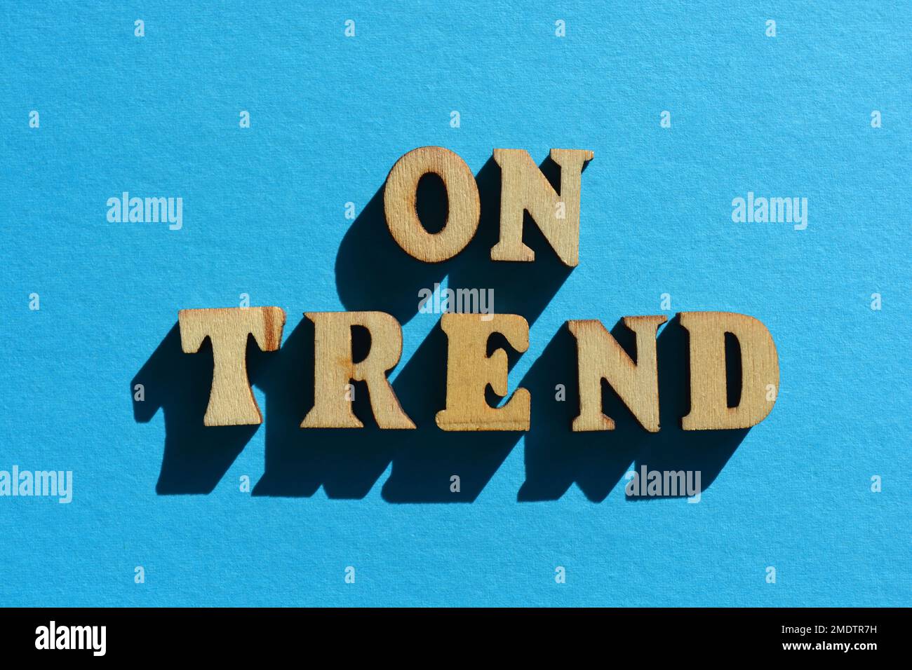 On Trend, words in wooden alphabet letters isolated on blue background ...
