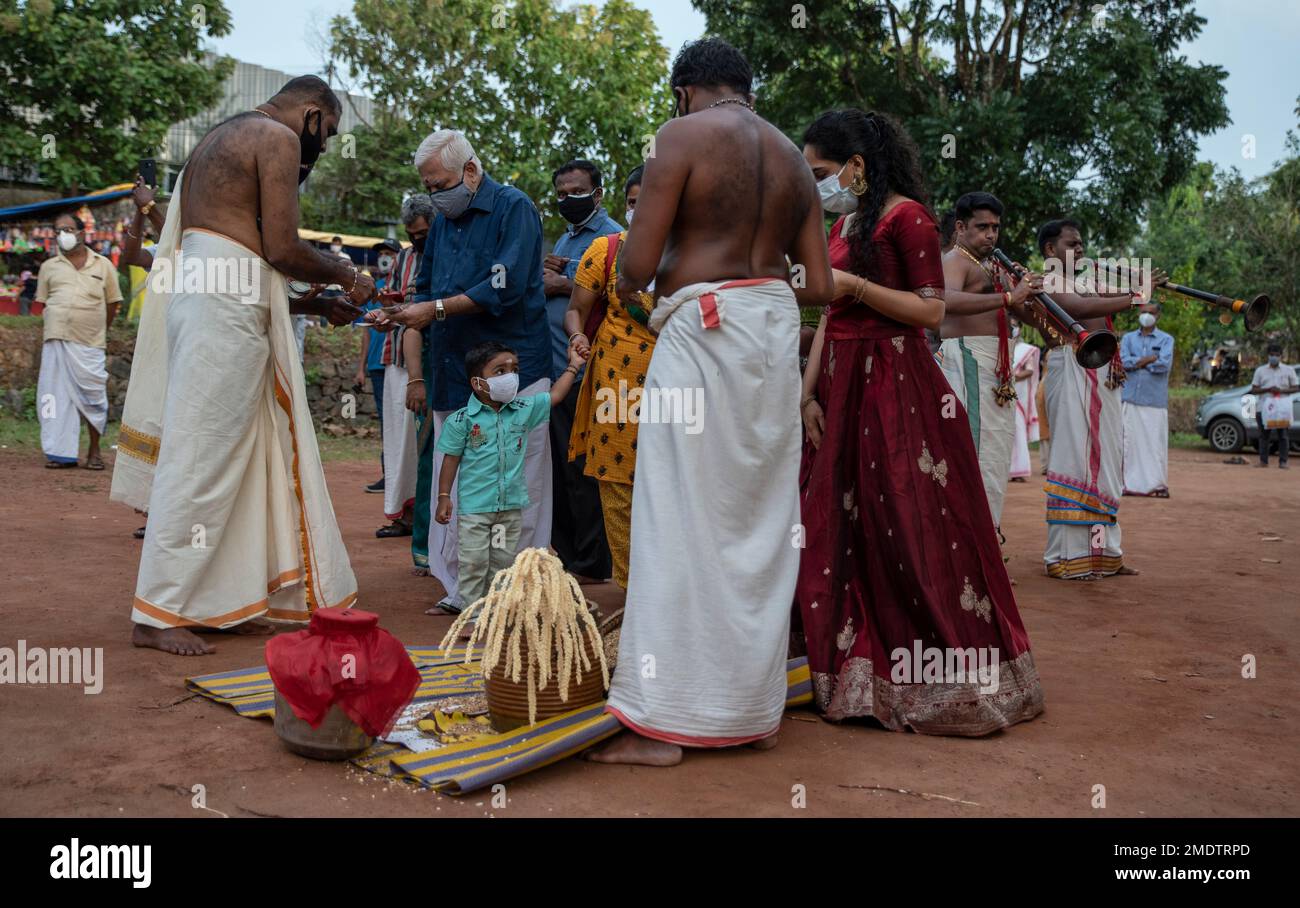 A child wearing mask as a precaution against the coronavirus watches ...