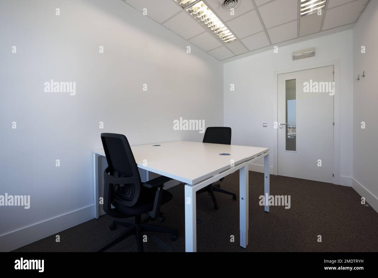 Office with double white wooden tables with white methacrylate dividers ...