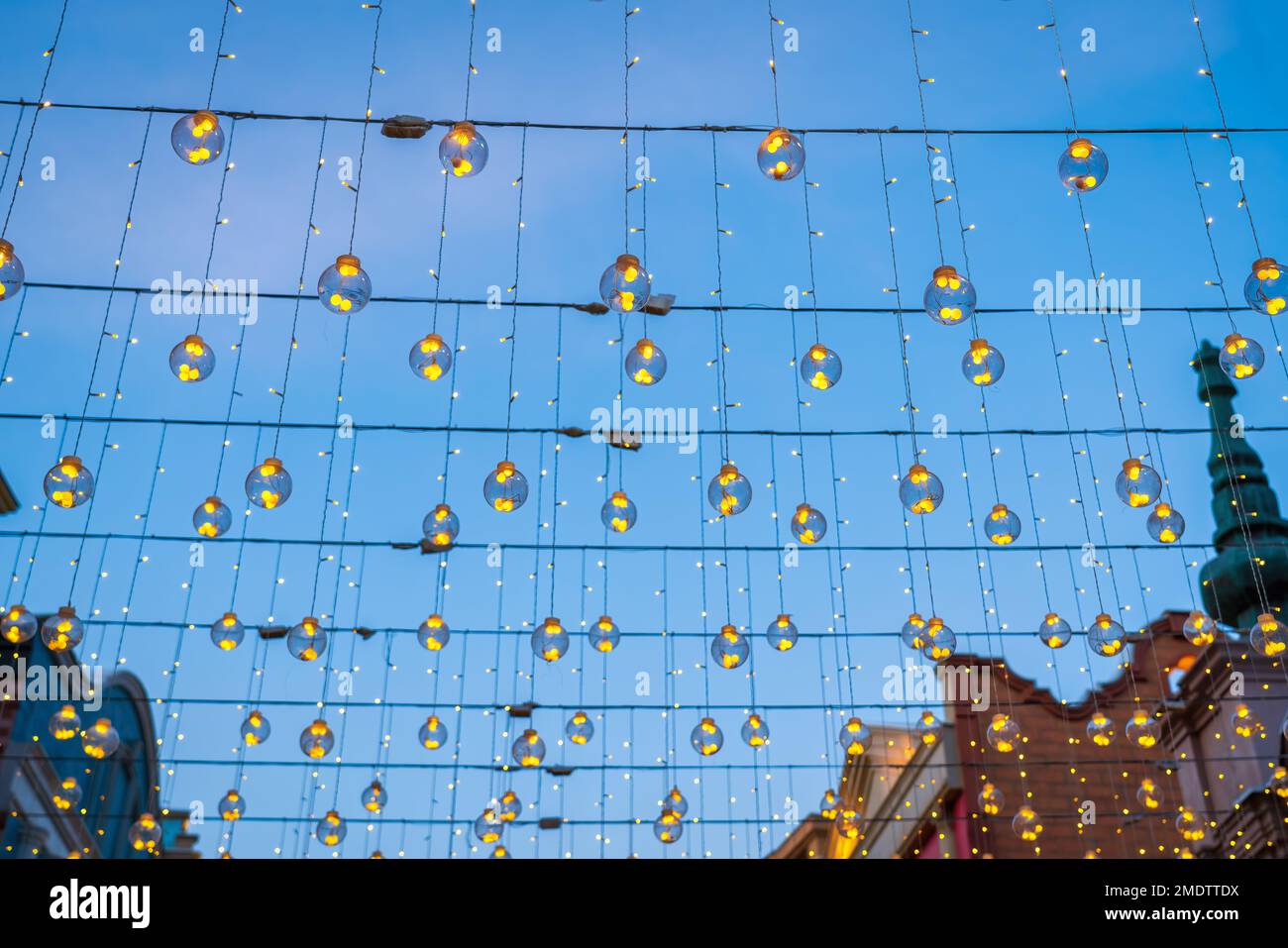 Festive hanging garlands with glowing light bulbs against the ...