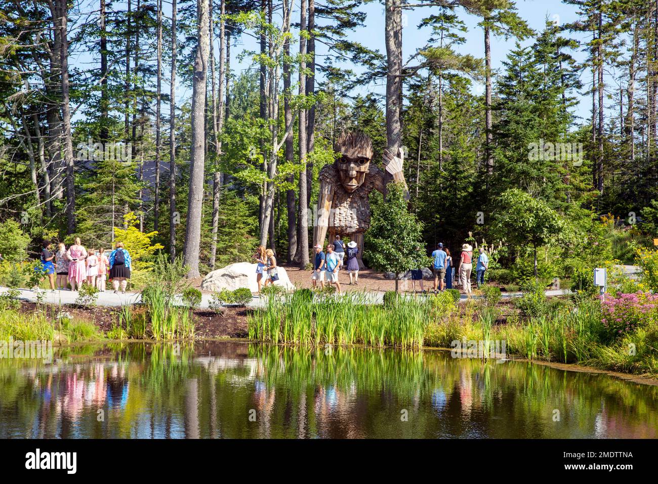 People walk by Roskva, a giant troll sculpture made from recycled wood ...