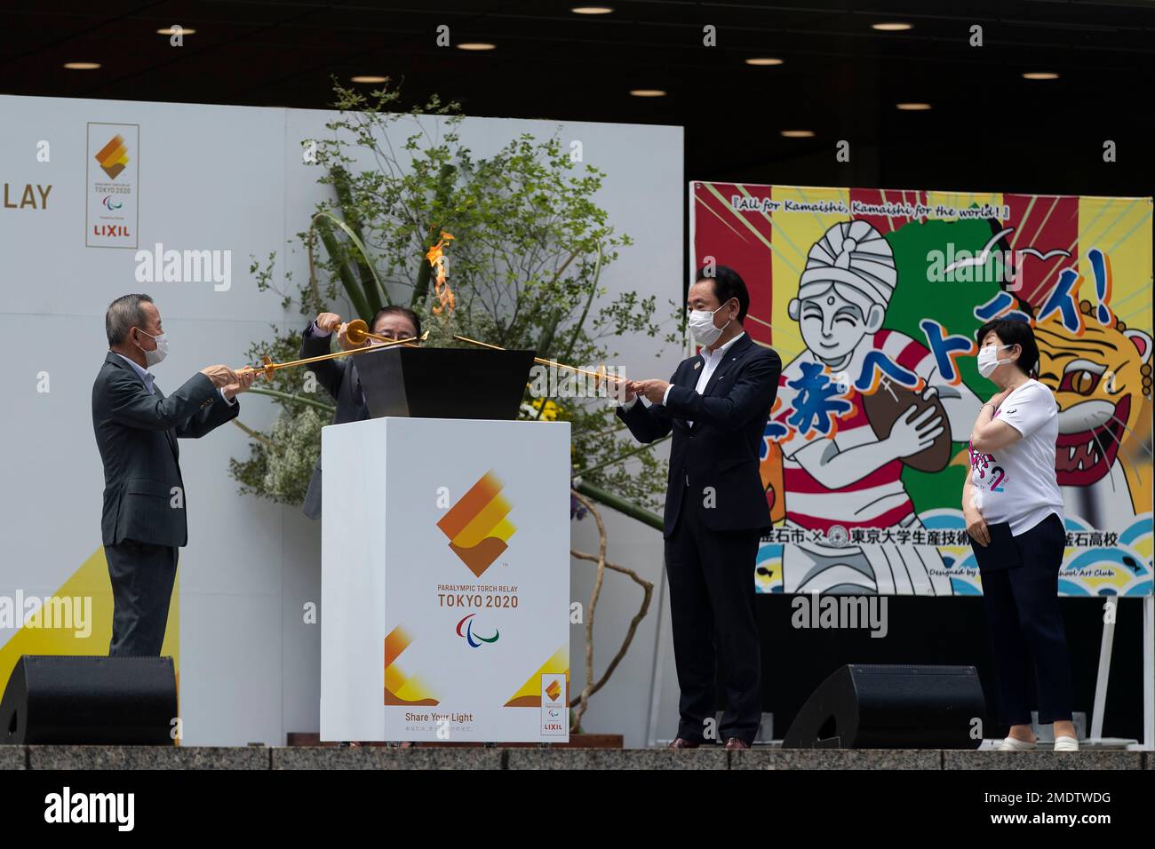 Tokyo Gov. Yuriko Koike, right, watches three men with flames make a ...